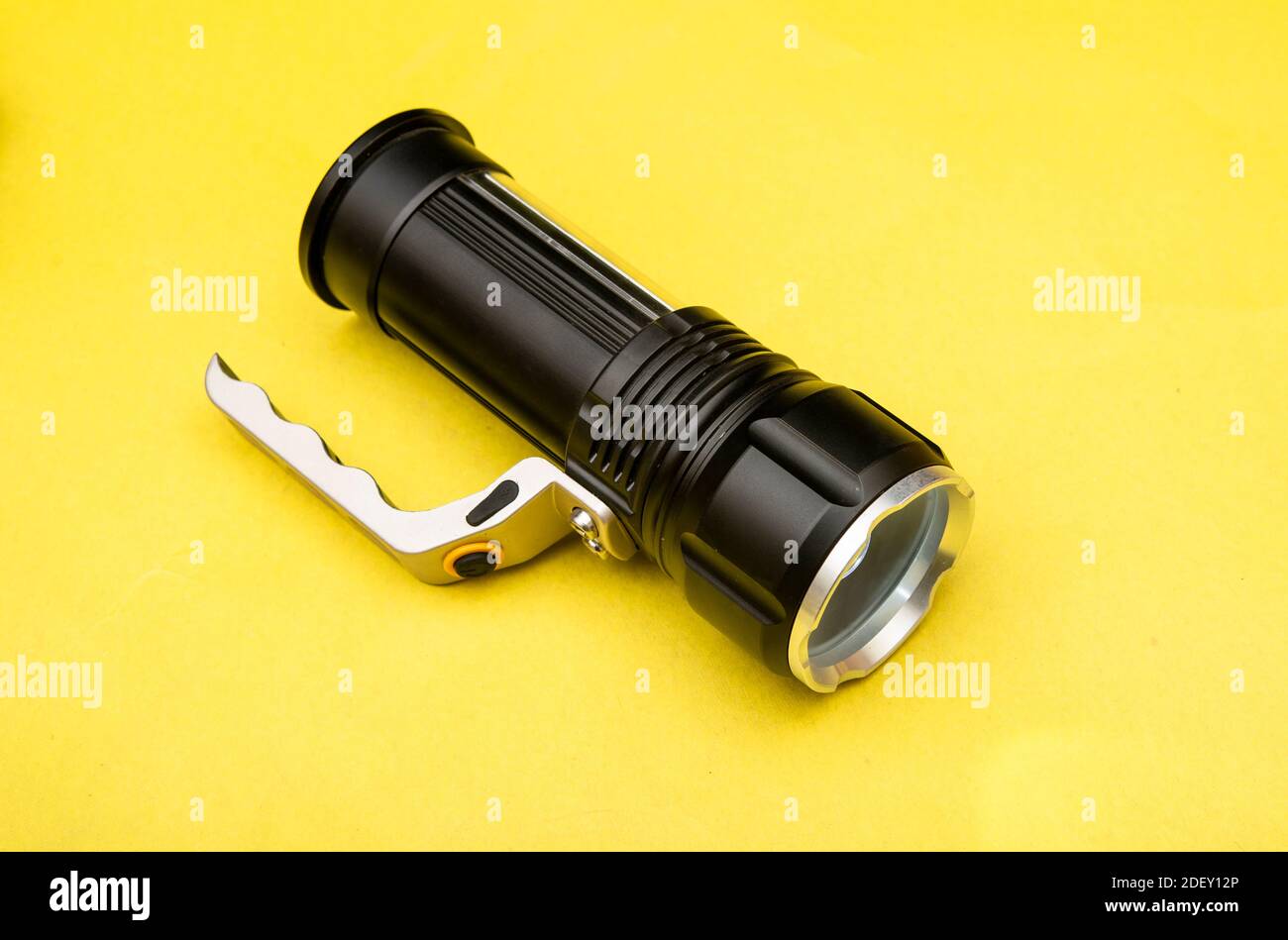 Black Flashlight on yellow table banner top view Stock Photo - Alamy