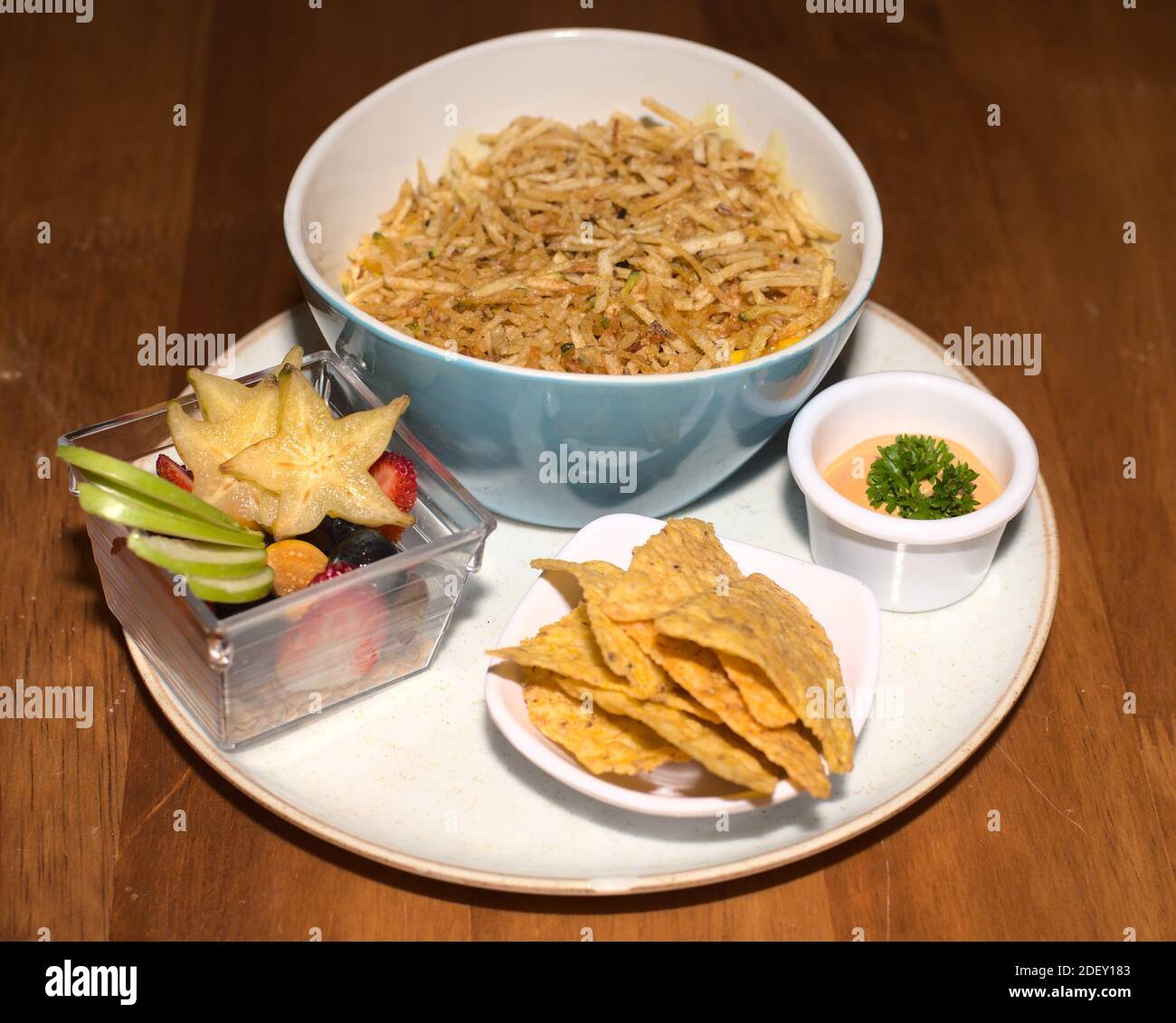 A top view closeup of nacho chips in a white bowl with rice, strawberry ...