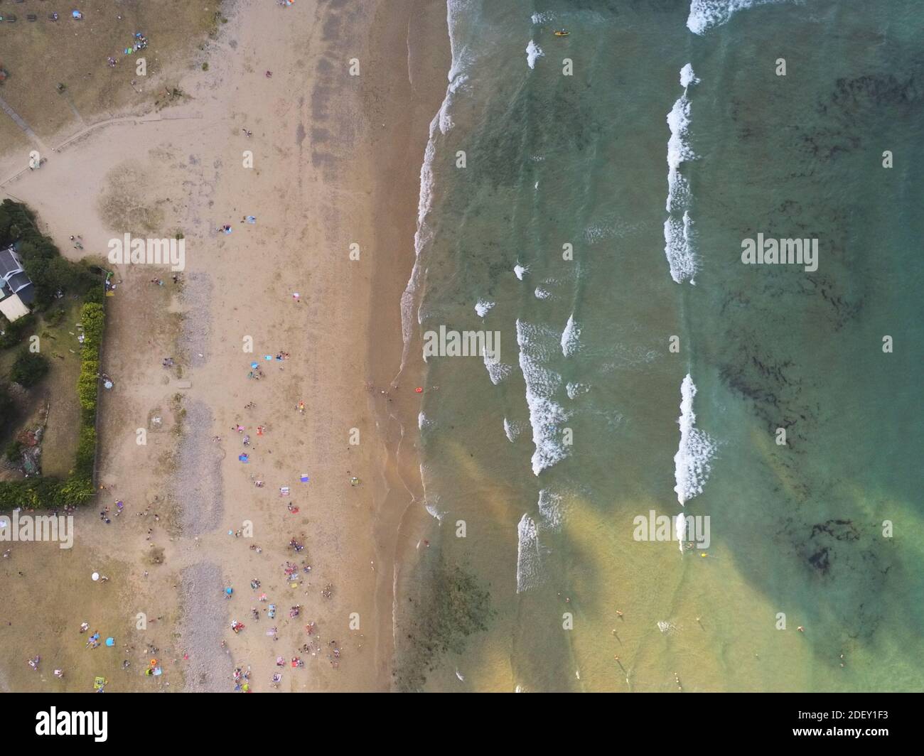 An aerial view of the wavy ocean hitting the Salamir sandy beach in ...
