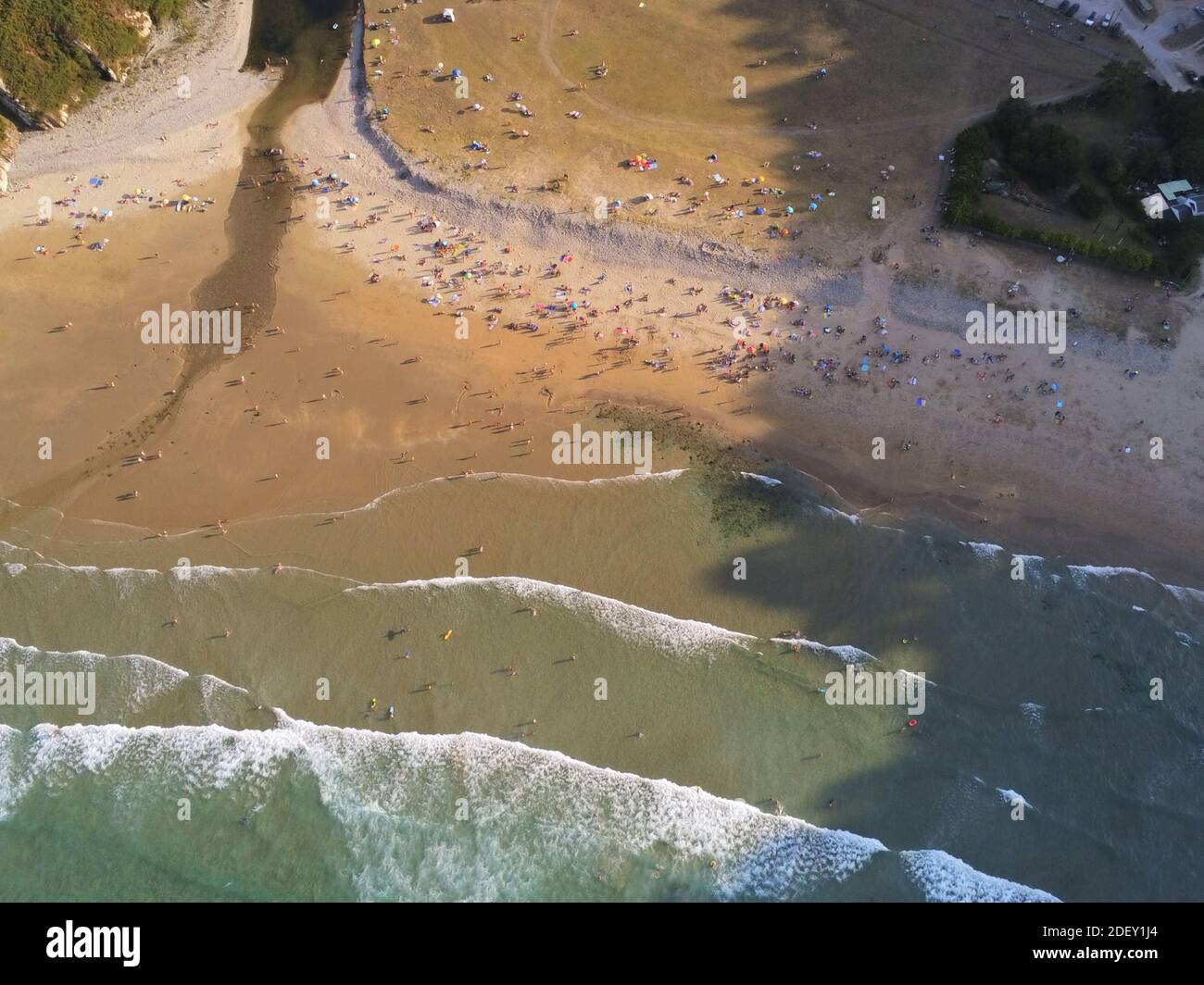 An aerial view of the wavy ocean hitting the Salamir sandy beach in ...