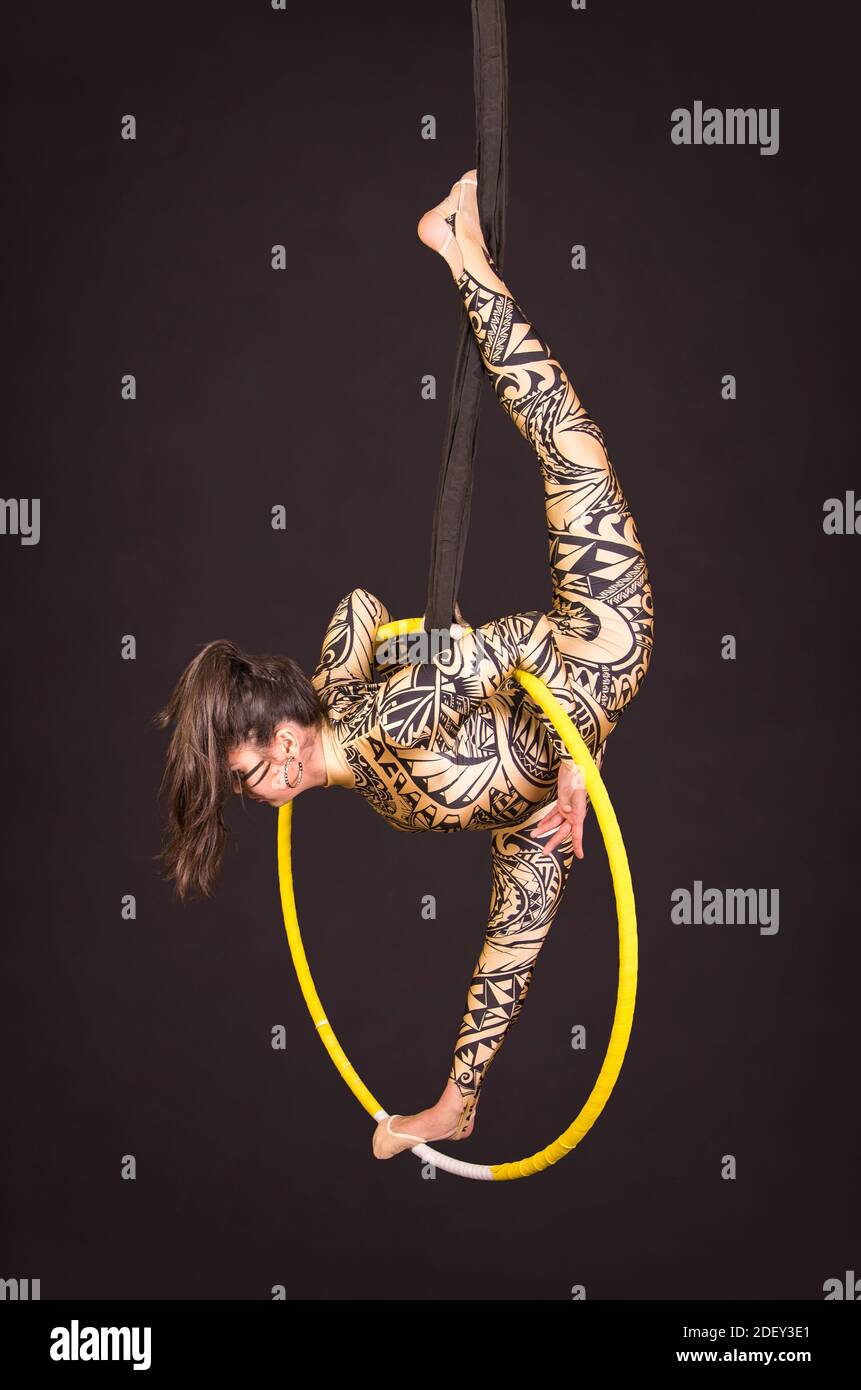 A young woman in a suit with a print performs acrobatic elements in the ...