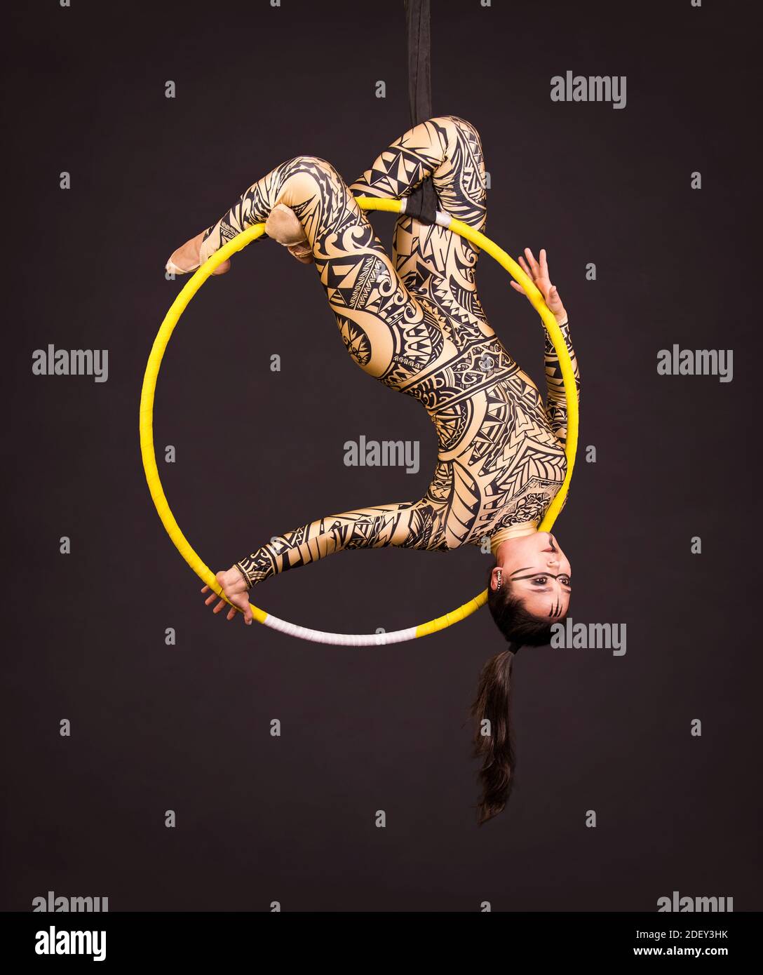 A young woman in a suit with a print performs acrobatic elements in the ...