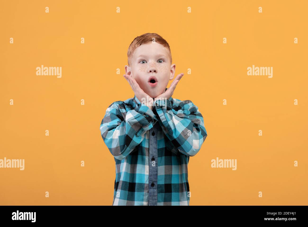 Shocked kid keeping mouth open and touching face Stock Photo - Alamy