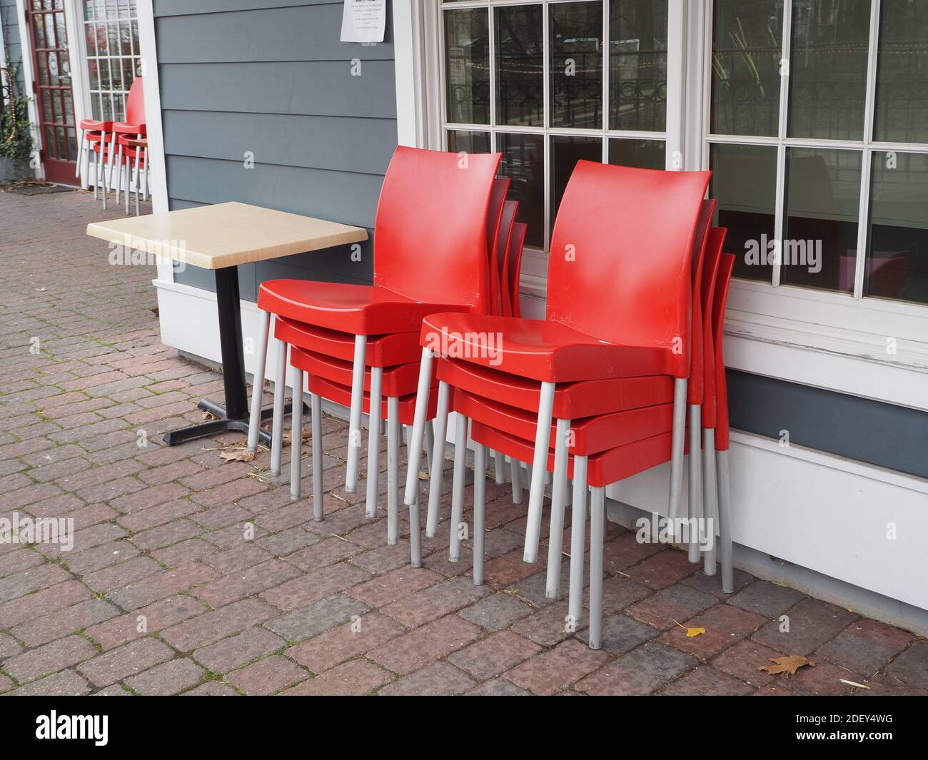 The red chairs are stacked up outside the restaurant Stock Photo - Alamy