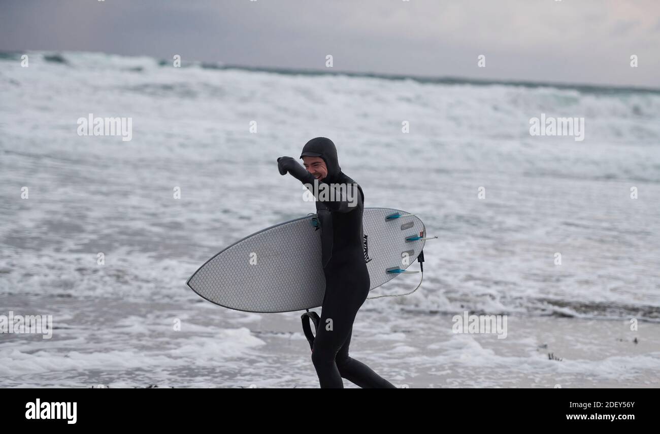 Arctic surfer going by beach after surfing Stock Photo - Alamy