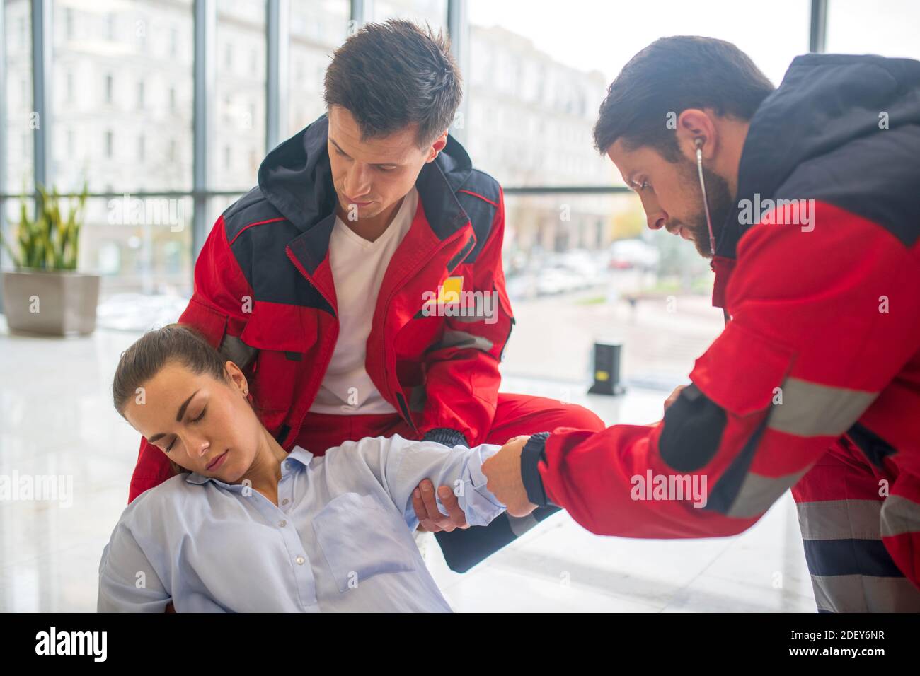 Ambulance crew giving first aid to the faint woman Stock Photo - Alamy