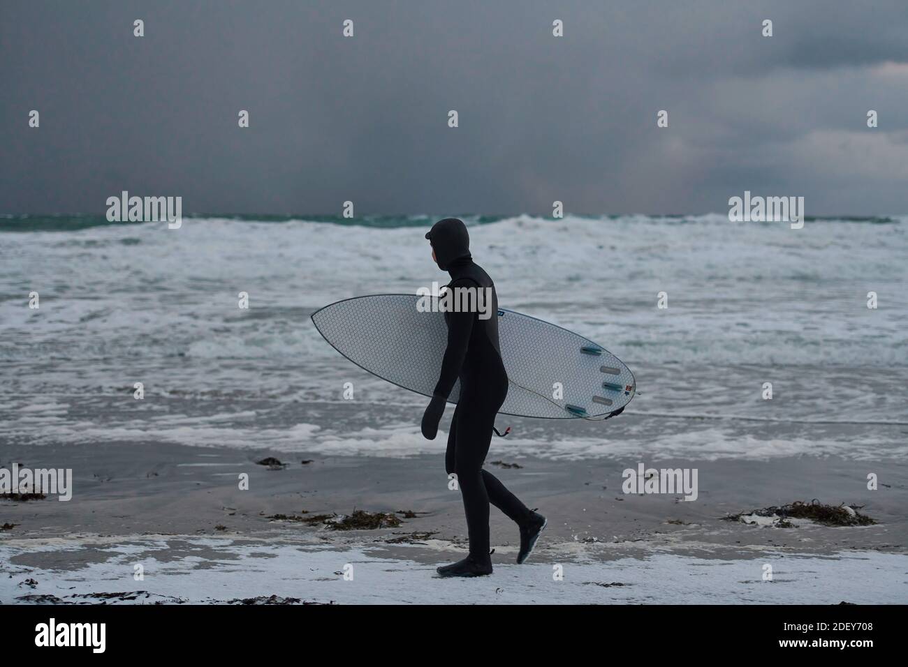 Arctic surfer going by beach after surfing Stock Photo - Alamy