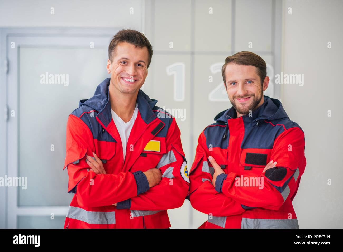 Two medical workers in red uniform smiling and feeling confident Stock ...