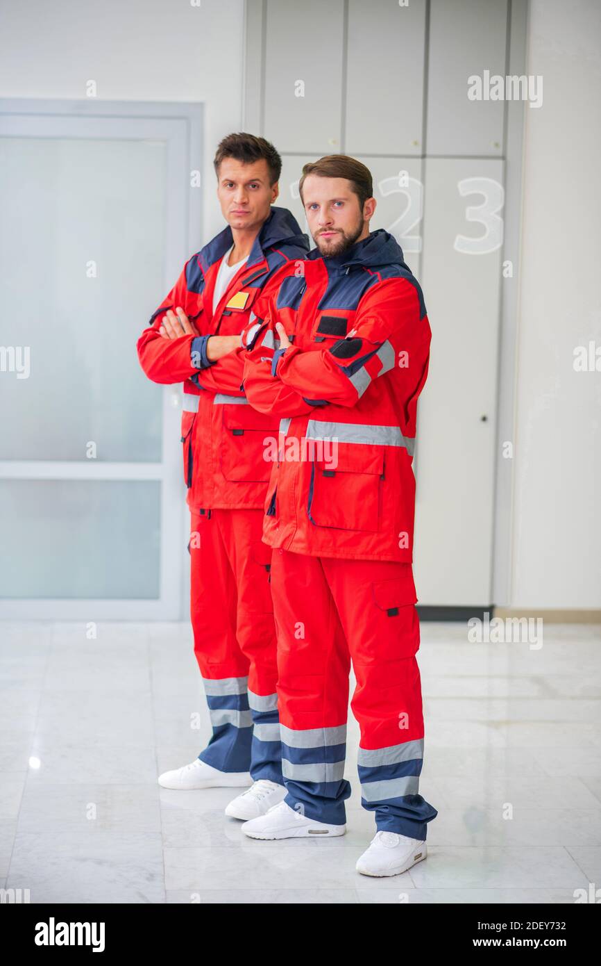 Two medical workers in red uniform standing in the corridor Stock Photo ...