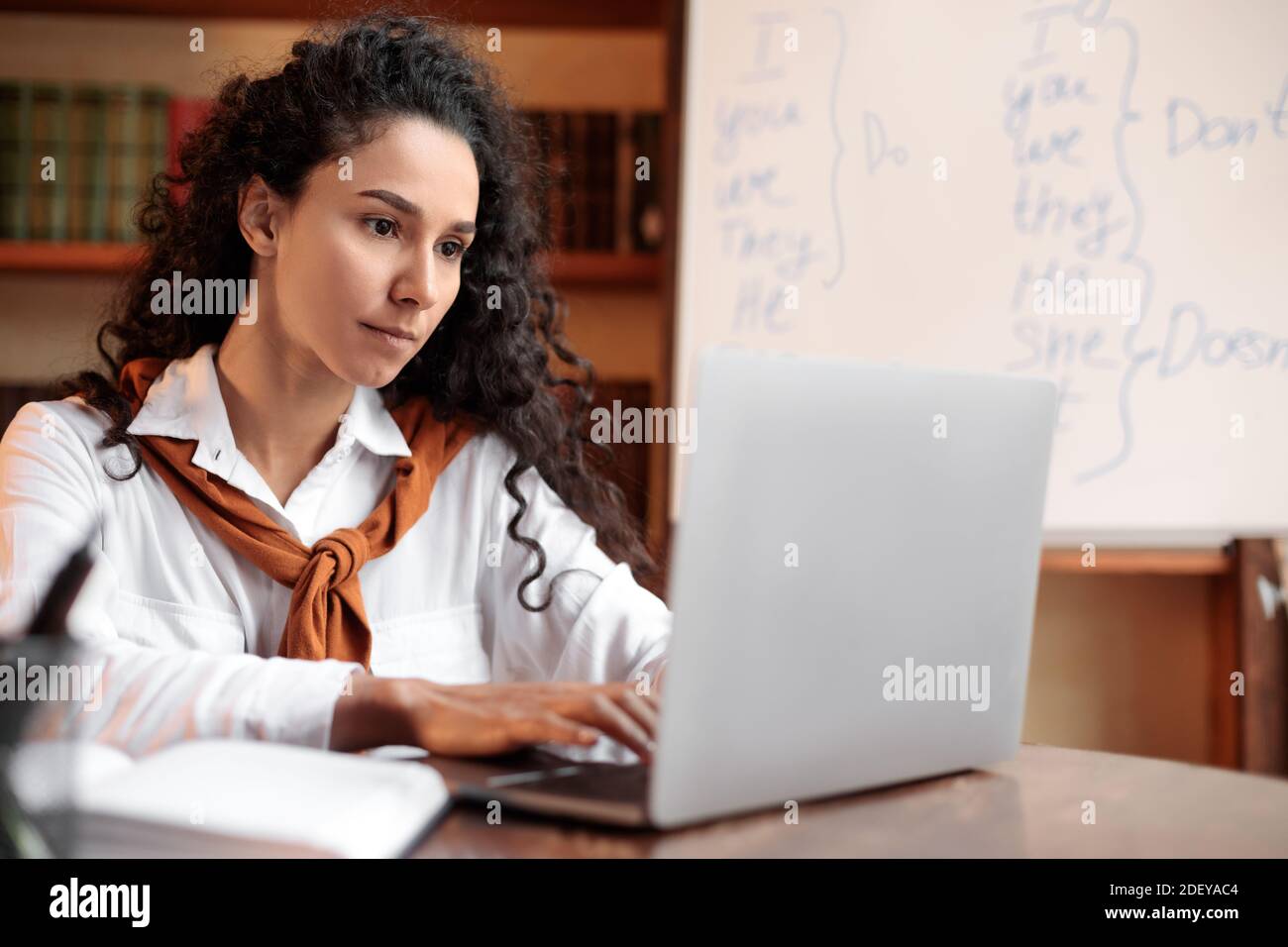 Lady sitting at desk, using computer and typing Stock Photo - Alamy