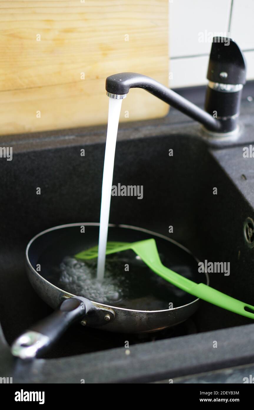 A vertical shot of a pan under water in sink Stock Photo - Alamy
