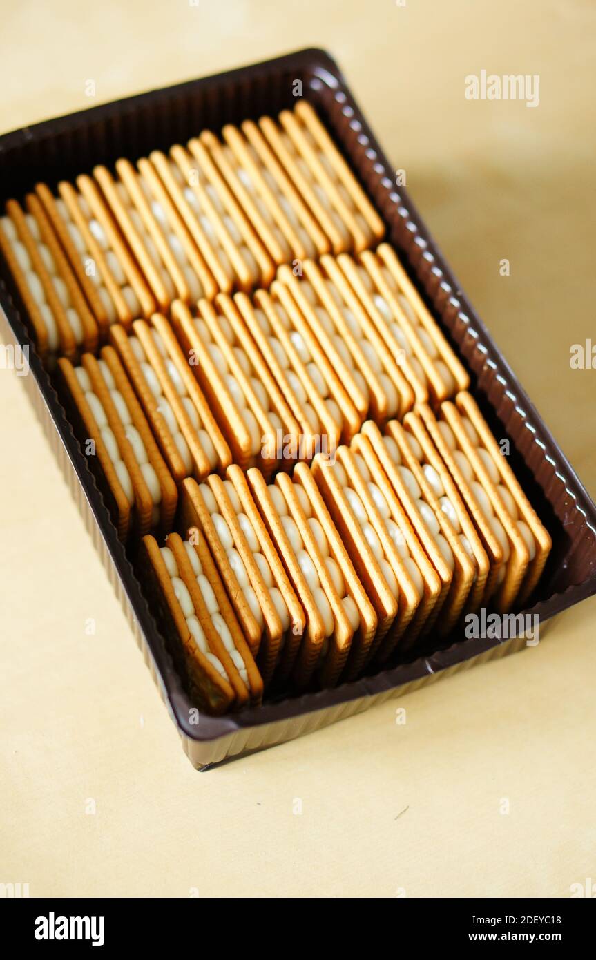 Delicious crispy square biscuits with cream filling in a retail package ...