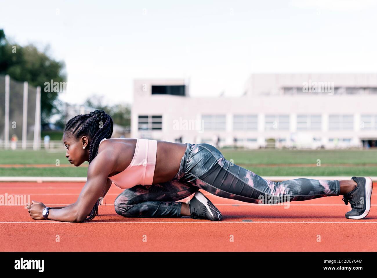 Stock photo of an African-American sprinter stretching her legs before ...