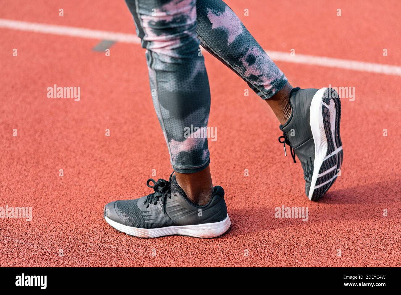 Stock photo of an African-American sprinter stretching her legs before ...