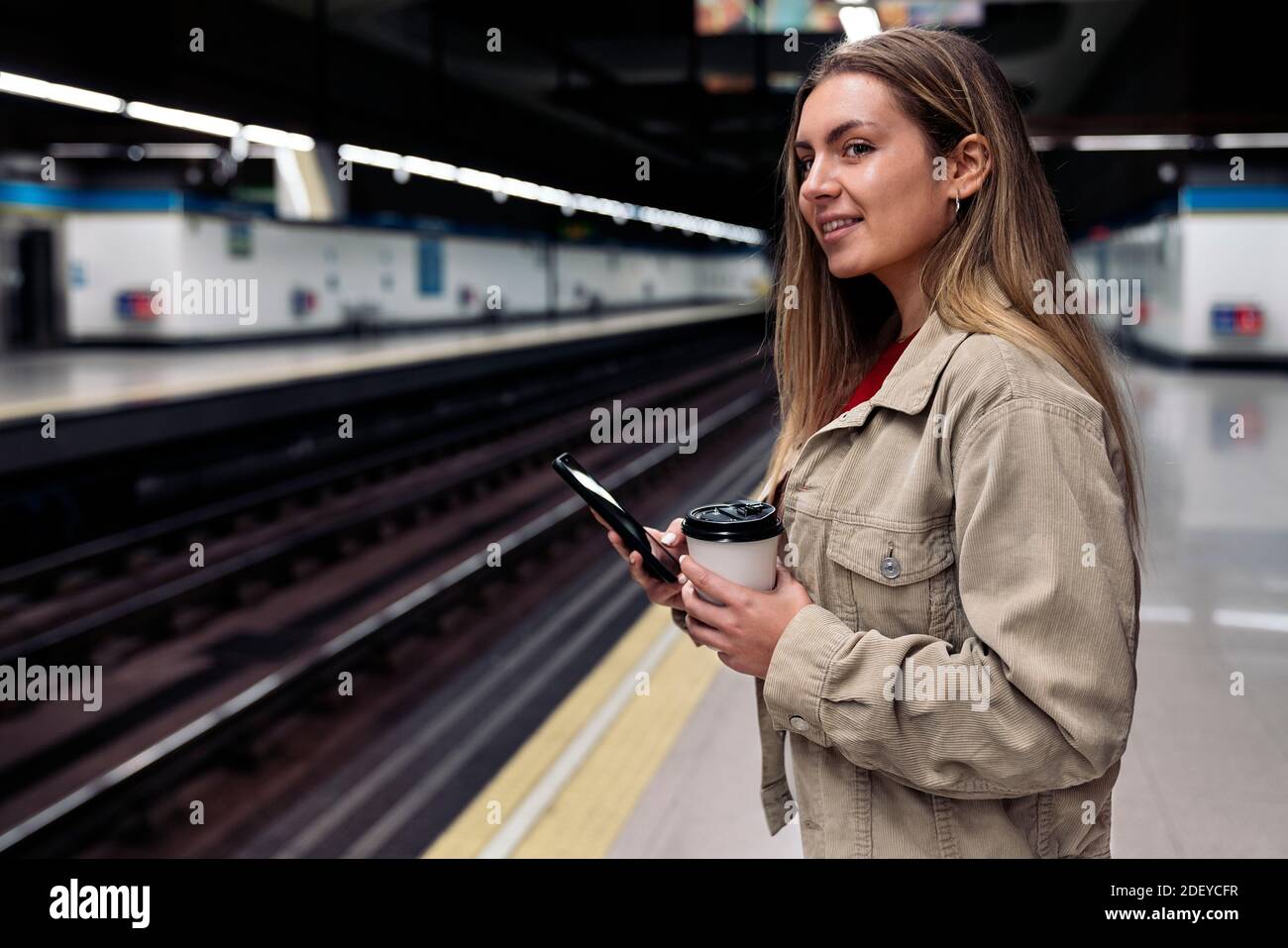Stock photo of pretty young girl waiting in the train platform using ...