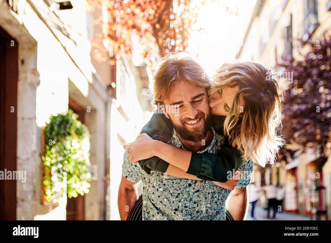 Stock photo of a couple in their 30s. The woman is on the mans back ...