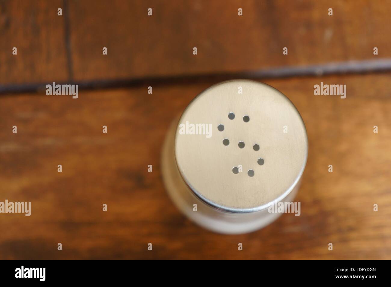 A top view closeup of the letter "S" on the cap of a kitchen salt on a ...