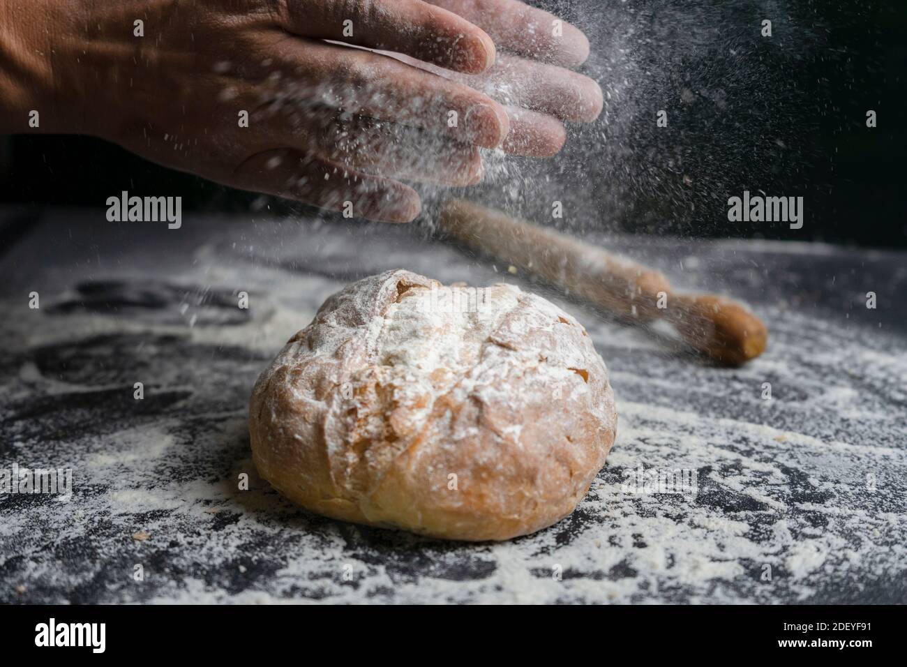 Baker clap hands with flour splash on fresh bread.Bakery concept ...