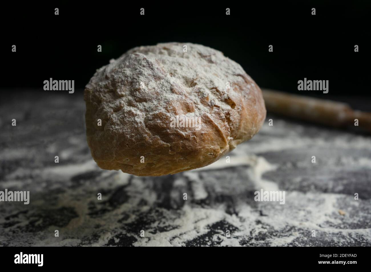 Bread falling or flying on floury black table.Concept of bakery, baking ...