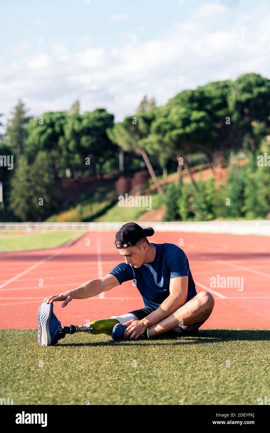 Disabled man athlete stretching with leg prosthesis. Paralympic Sport ...