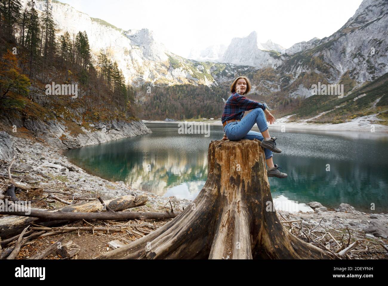 beautiful girl sits on a stump and smiling at the camera on a ...