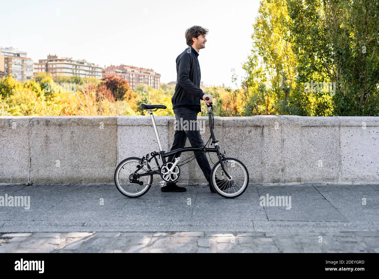Stock photo of handsome man using his detachable bike in the street ...