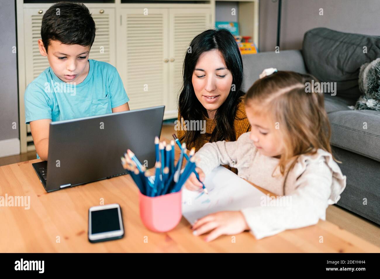 Stock photo of lovely kids using laptop and drawing in the living room ...