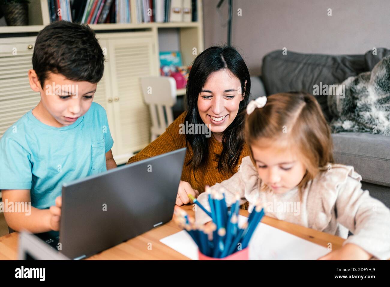 Stock photo of lovely kids using laptop and drawing in the living room ...