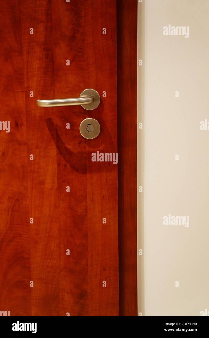 A vertical shot of a metal handle on a wooden door Stock Photo - Alamy