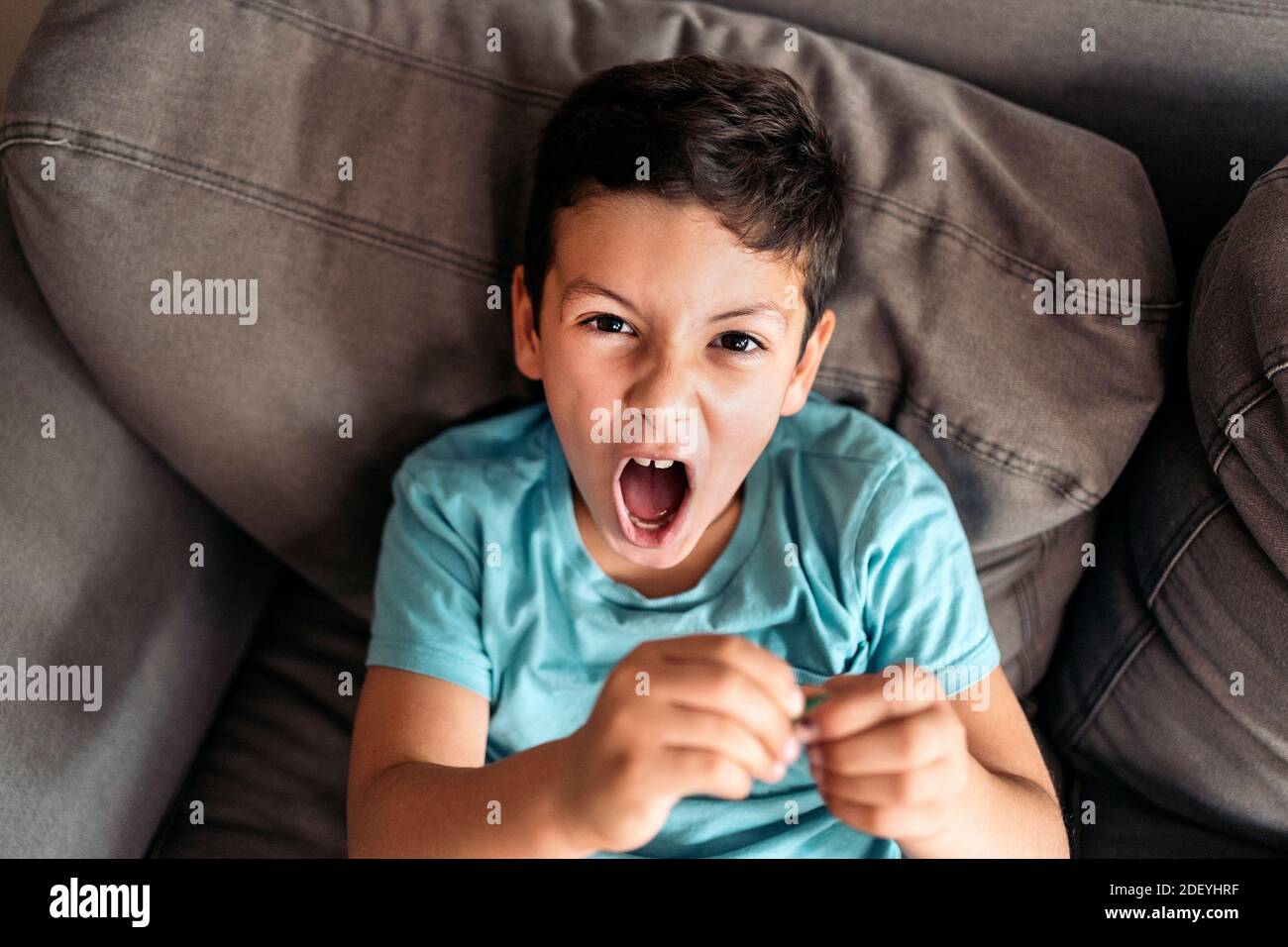 Stock photo of funny little boy looking at camera while sitting on the ...