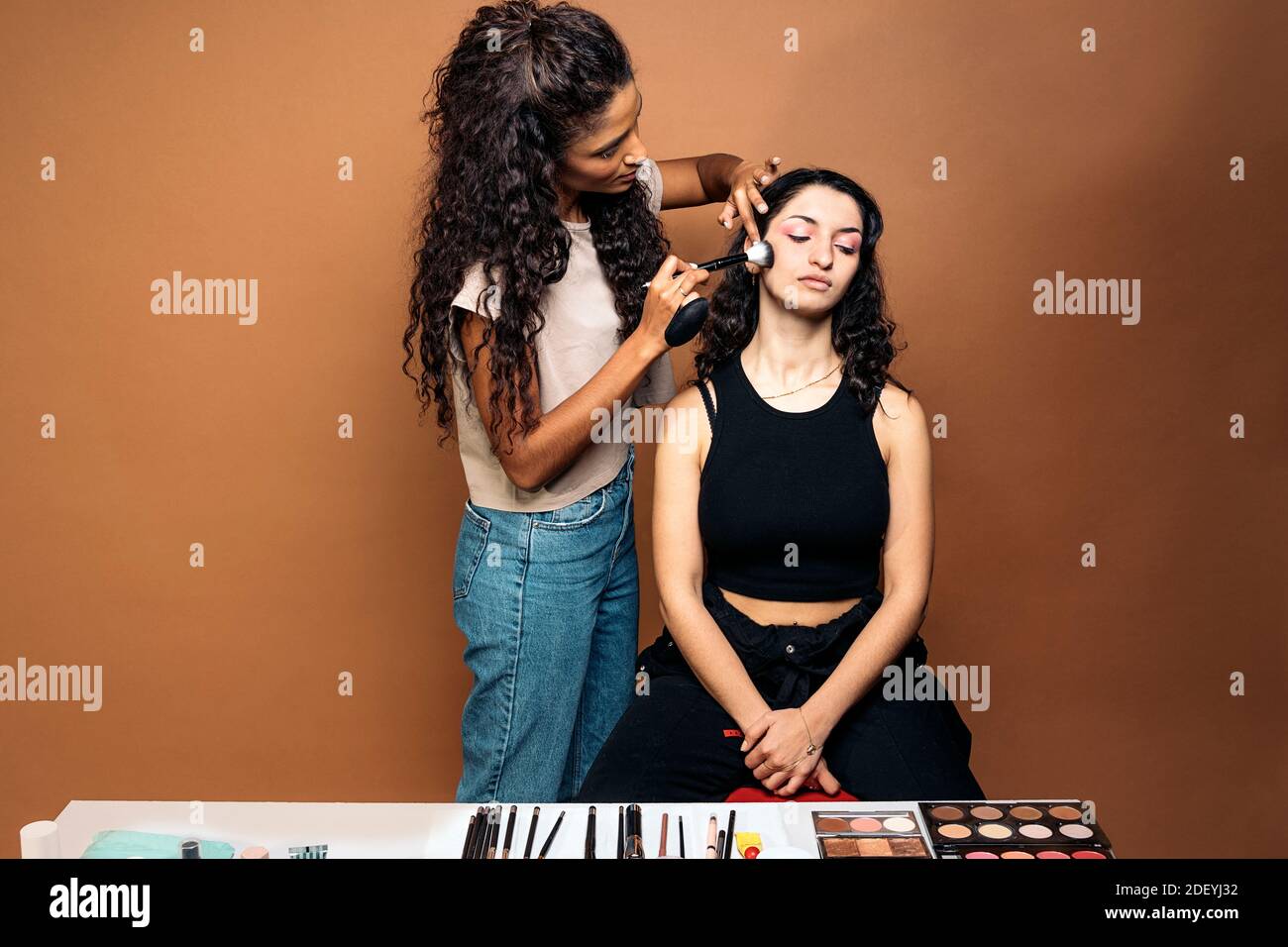 Stock photo of beautiful young woman doing makeup to her client in ...