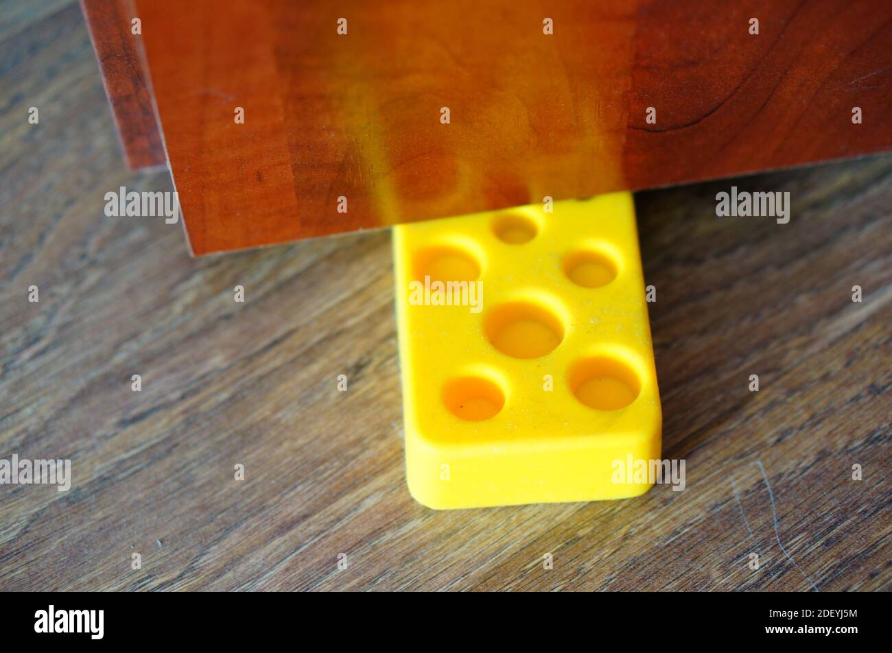 A vertical shot of a yellow cheese shape door blocker Stock Photo - Alamy