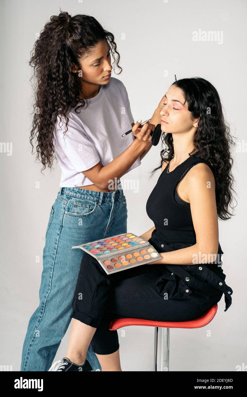 Stock photo of happy make up artist using brush to apply eye shadow to ...