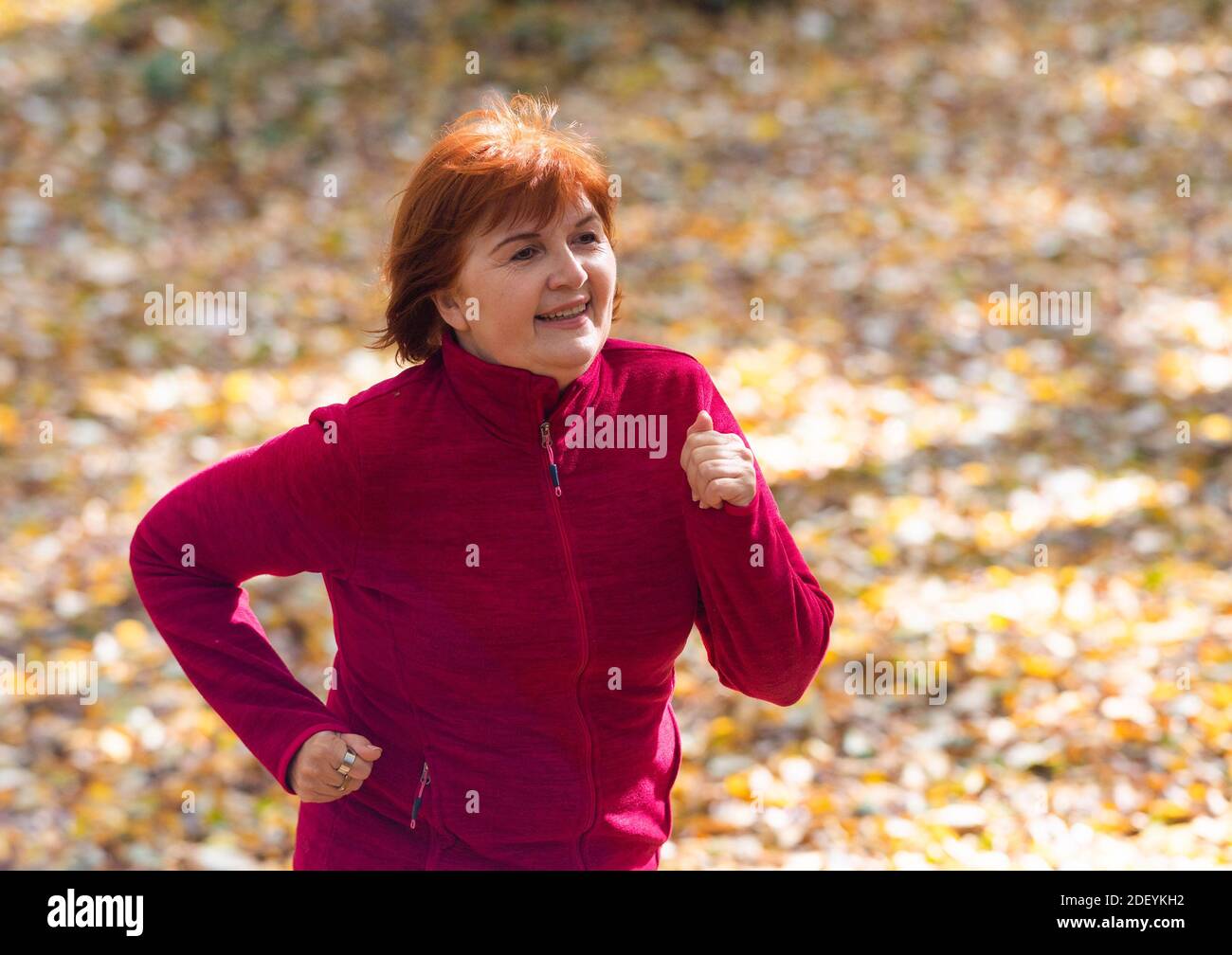 Active middle-aged woman jogs runs on nature Stock Photo - Alamy