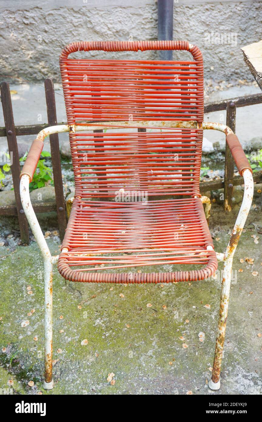 A vertical shot of a red old rusty garden chair on asphalt Stock Photo ...