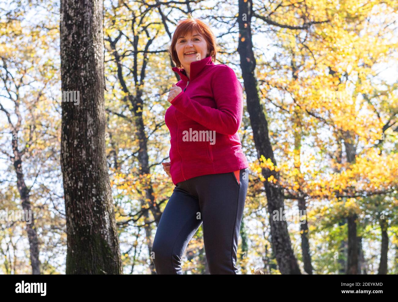Active middle-aged woman jogs runs on nature Stock Photo - Alamy