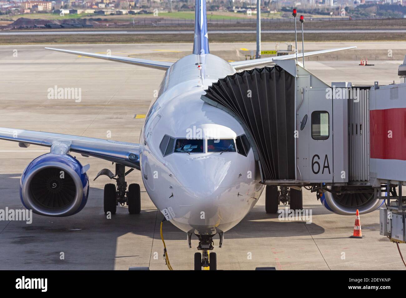 Front view of a Boeing 737 type jet on the airport apron. Jet bridge ...