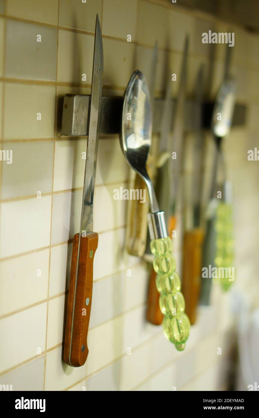 A vertical shot of kitchen utensils fixed on the wall with magnet Stock ...