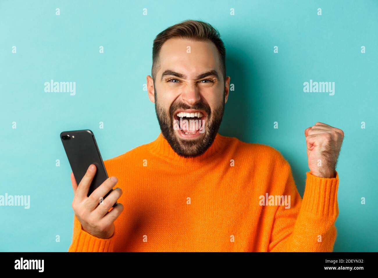 Image of man winning on mobile phone, making fist pump and rejoicing of ...