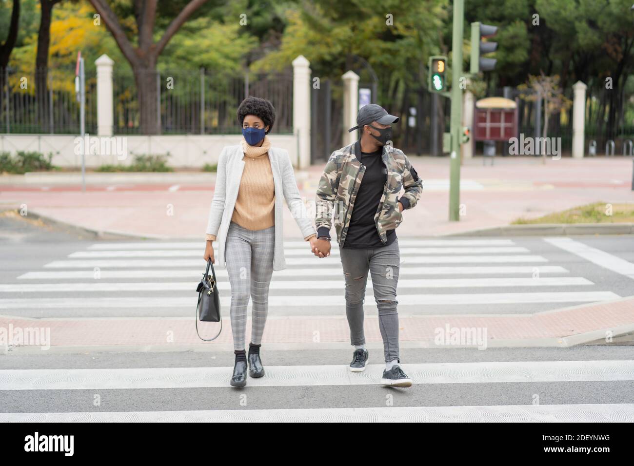 African wedding couple crossing the road hand in hand Stock Photo - Alamy