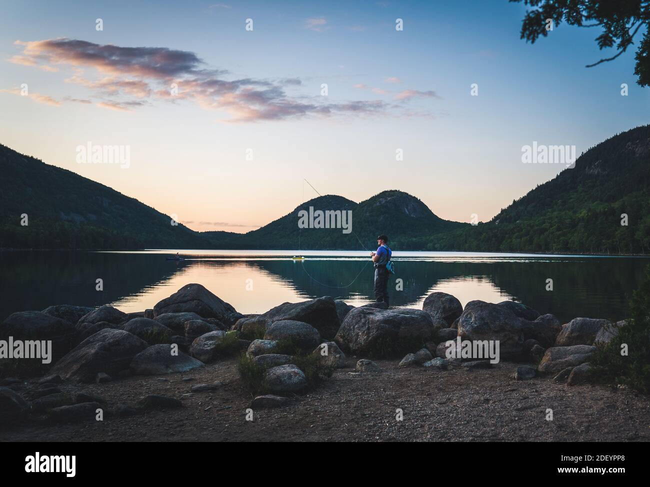 Man standing with fly fishing rod at Jordan Pond, Acadia National Park ...