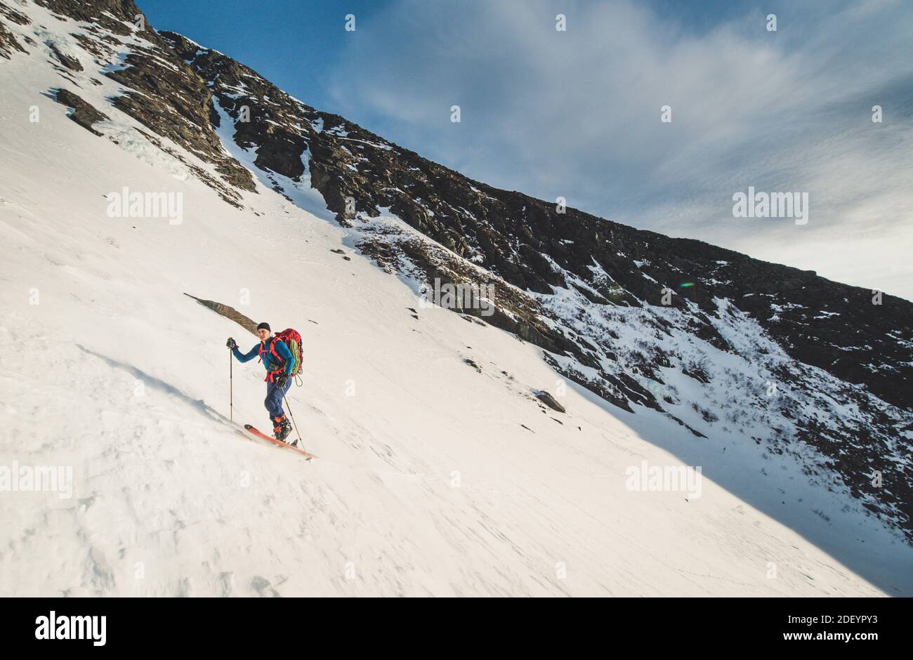 Skier ascends Huntington Ravine during sunrise in the White Mountains ...