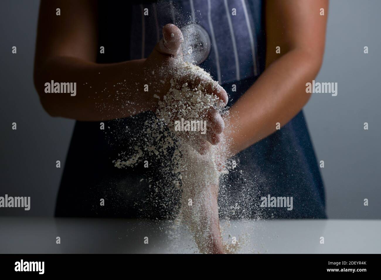 Woman shaking flour in her hands for making bread Stock Photo - Alamy