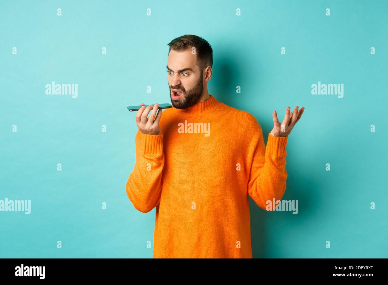 Angry man arguing on speakerphone, record voice message with mad face ...