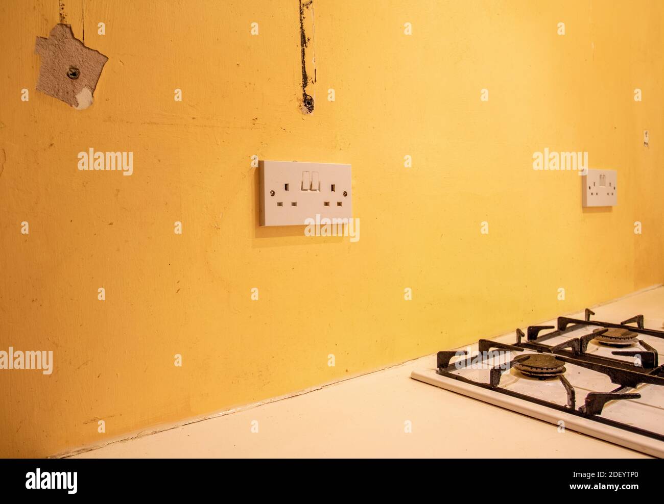 Yellow ochre kitchen wall with electric sockets during a kitchen ...