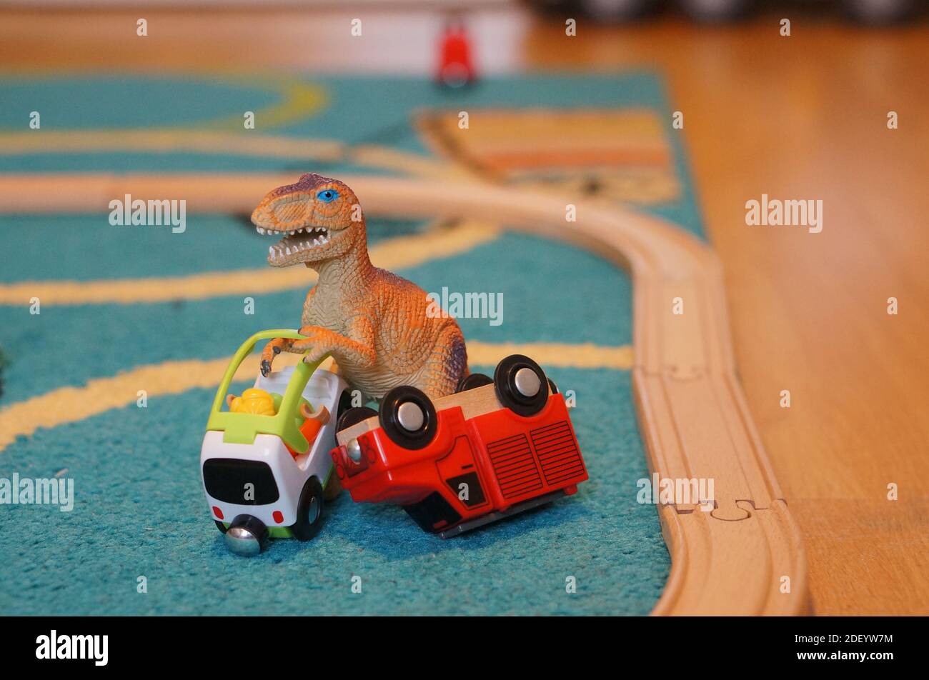 A selective focus shot of toy tyrannosaurus rex lifting a toy car Stock ...