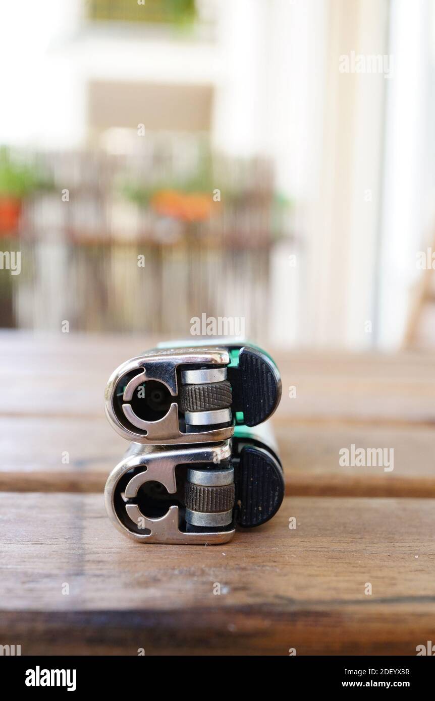 A vertical selective focus clsoeup of two stack of lighters on a wooden ...