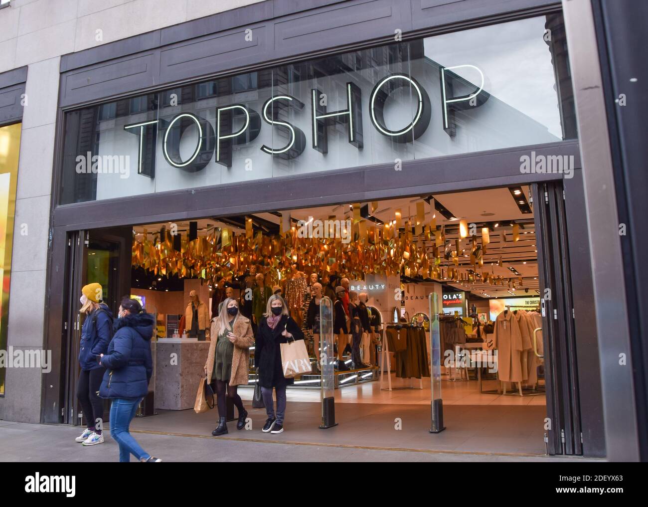 Customers wearing protective face masks walk out of Topshop on Oxford ...