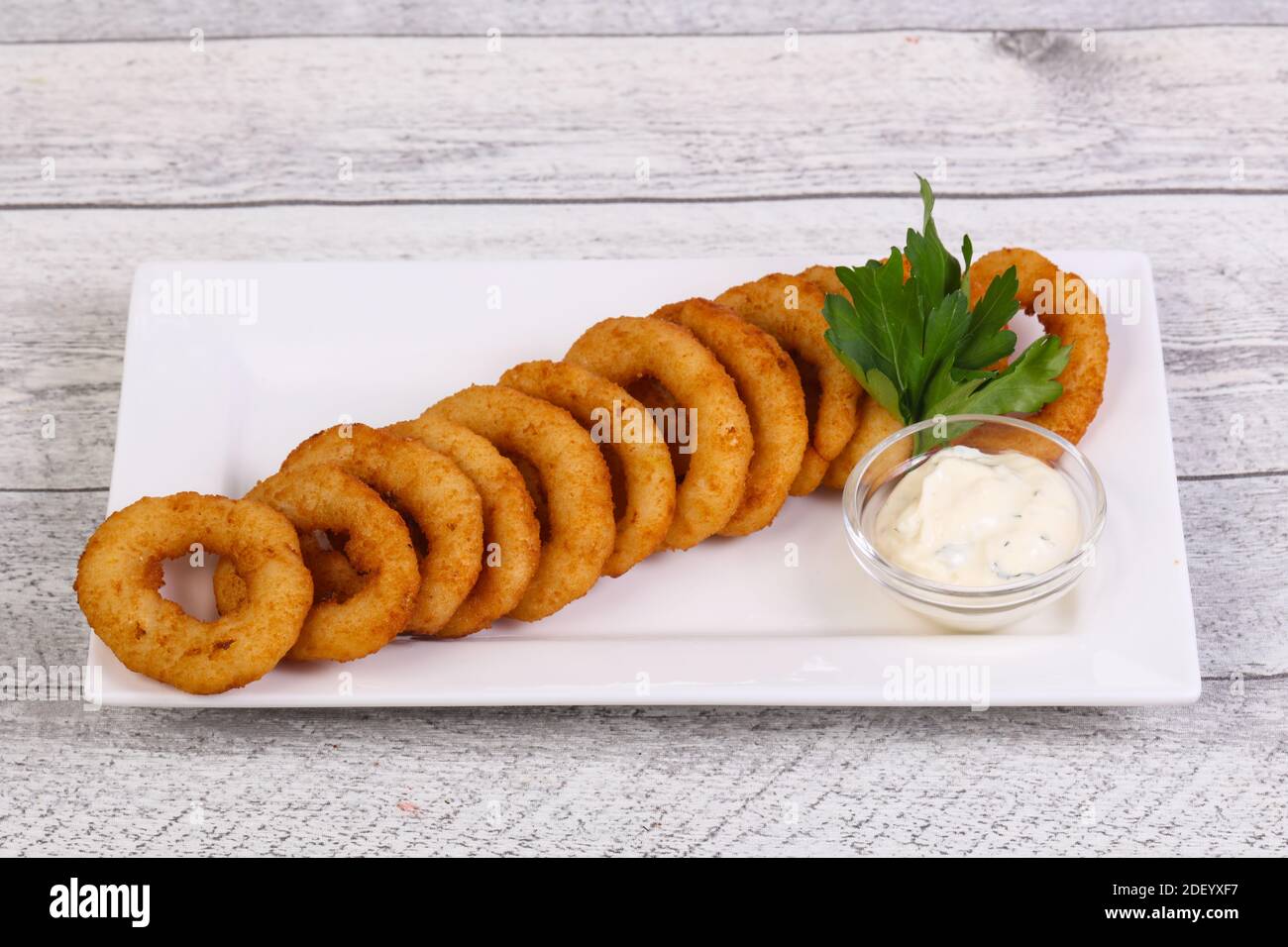 Squid rings snack with sauce served parsley Stock Photo - Alamy
