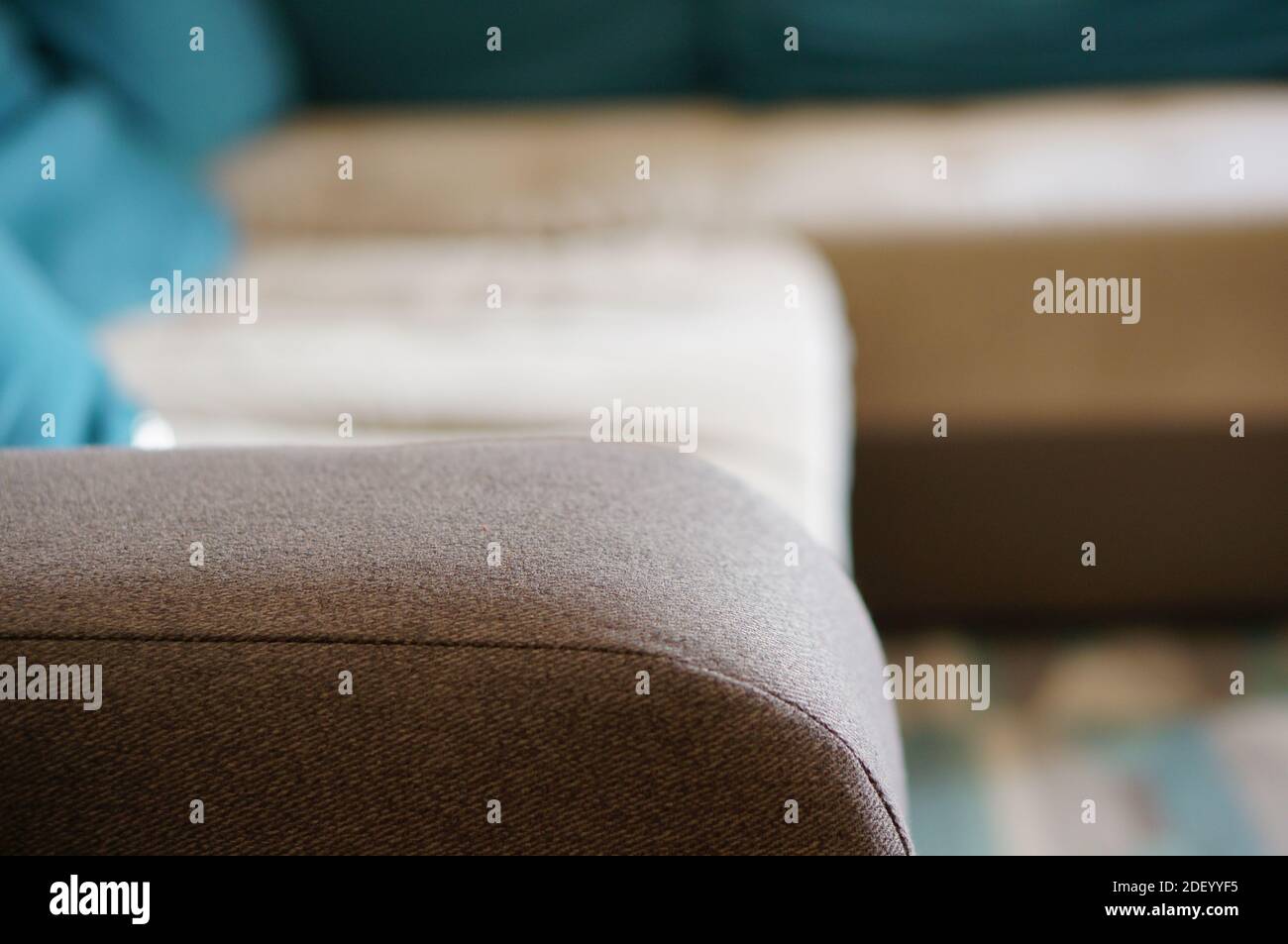 A closeup of the arm of a soft comfortable sofa in a house with a ...